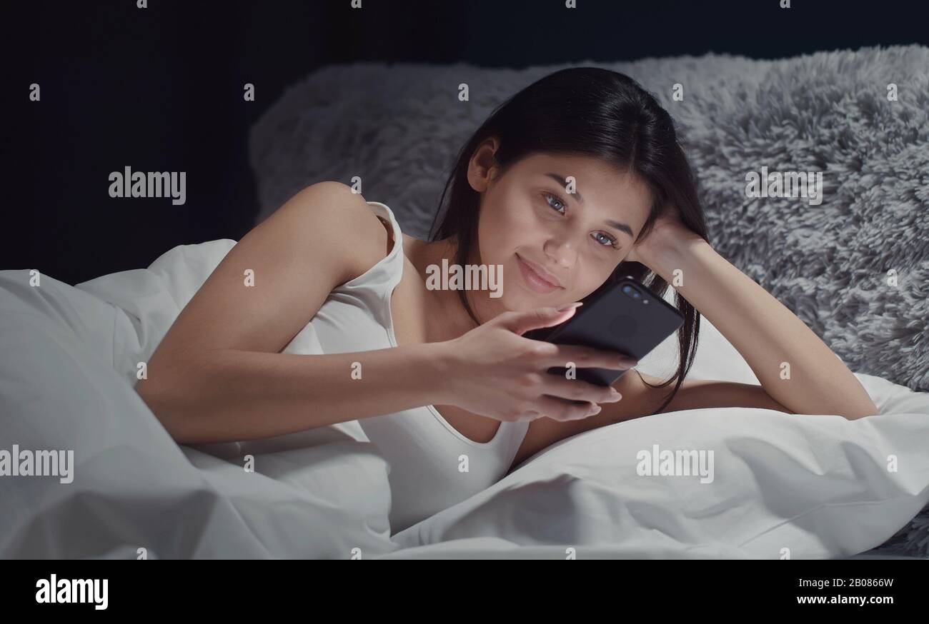 Girl typing smartphone in bed Stock Photo - Alamy