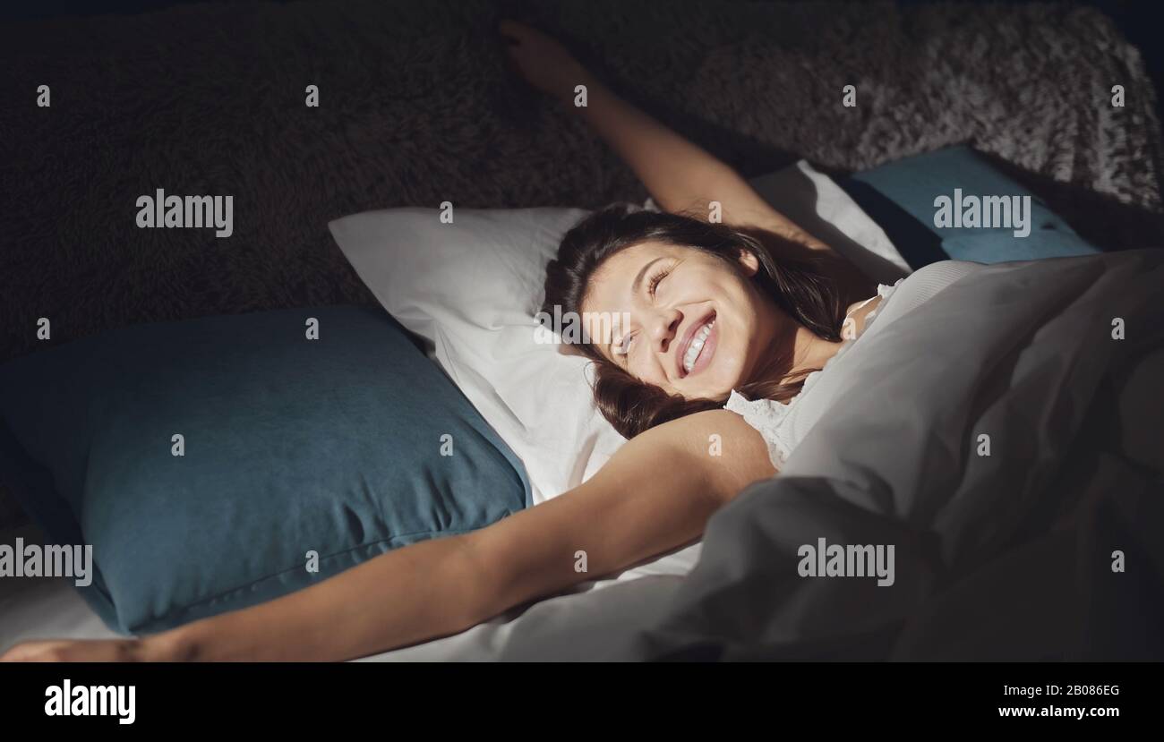 Female stretching in bed Stock Photo - Alamy