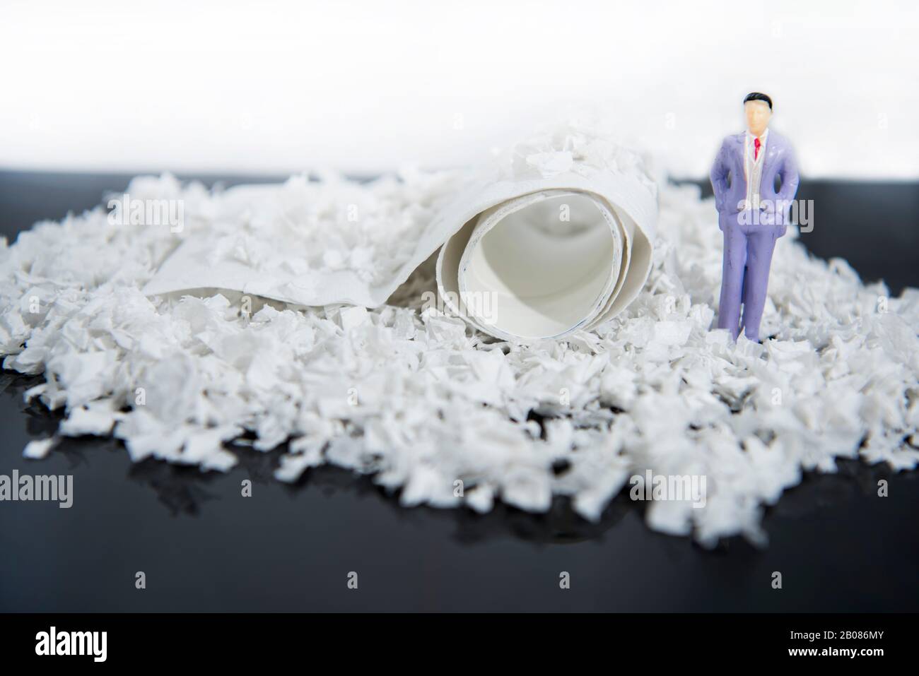 Abstract photo with toilet paper and some small people figures. Waste ...