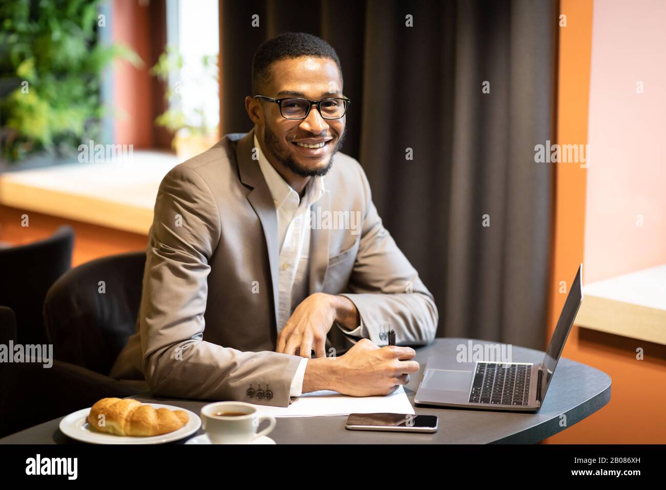 Black business man taking notes on the paper Stock Photo - Alamy