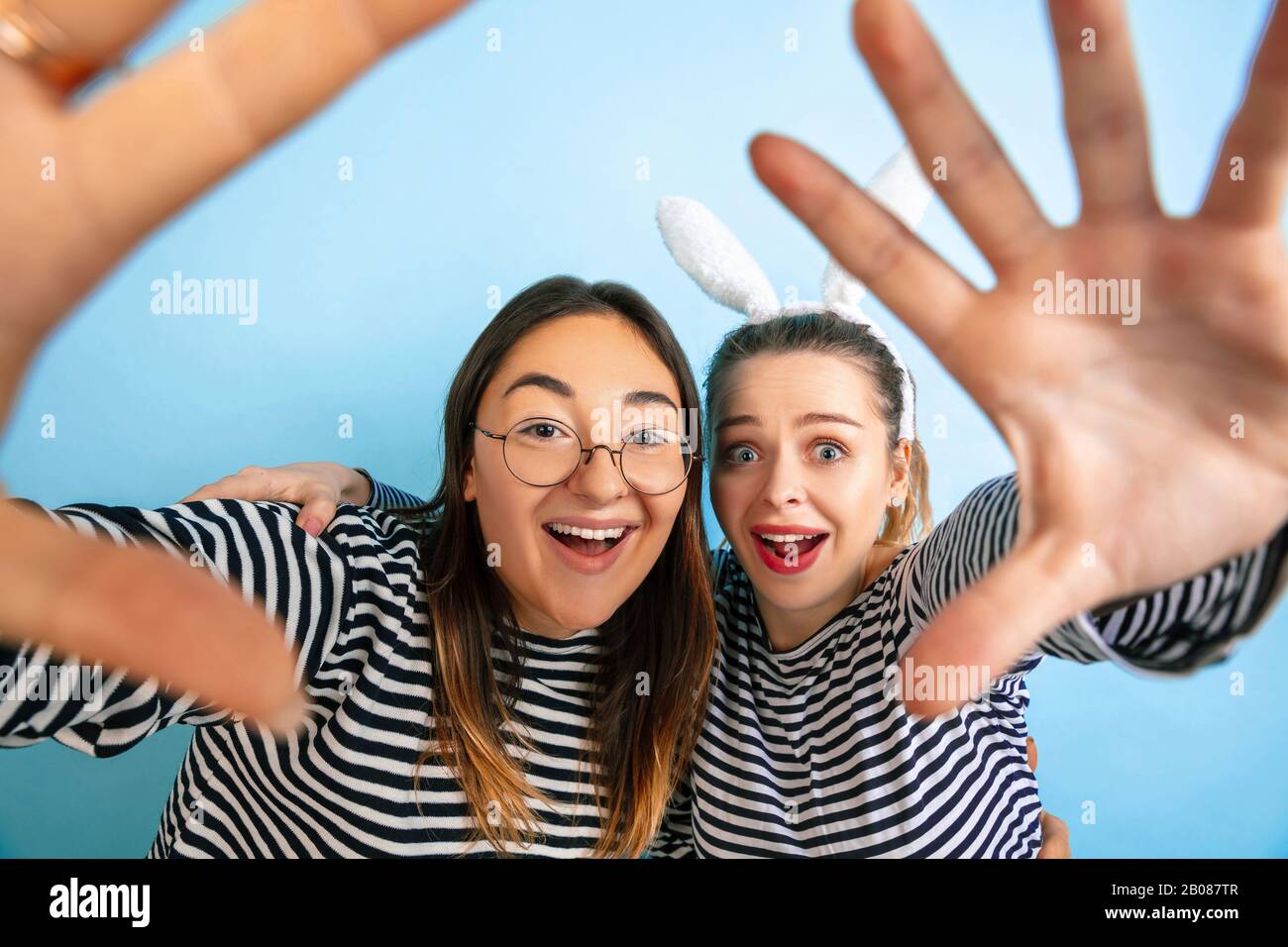 Scared, astonished. Young emotional women isolated on gradient blue ...