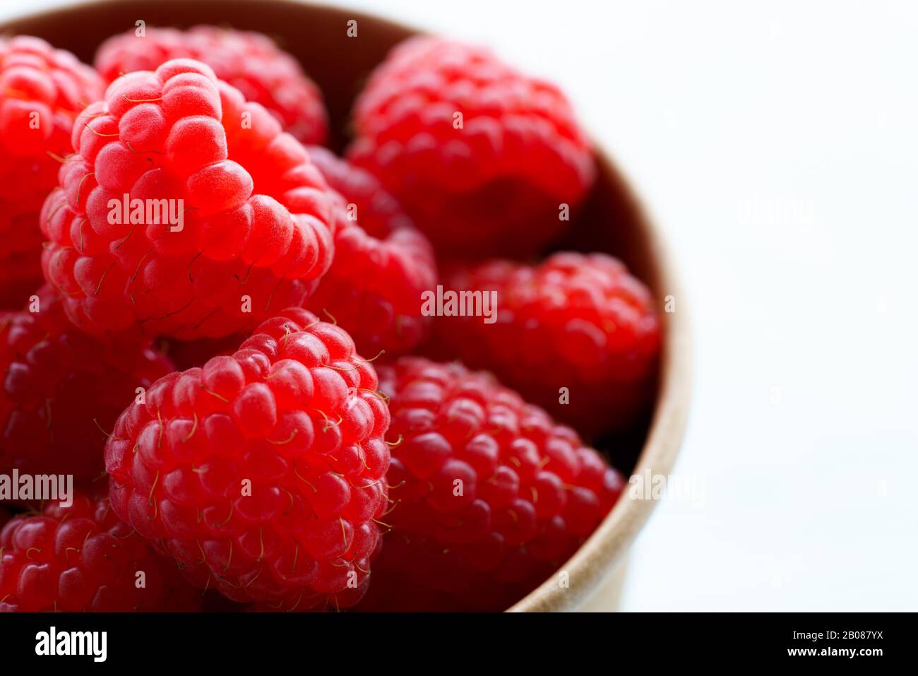 Freshly picked organic raspberries in recycled paper cup. High ...