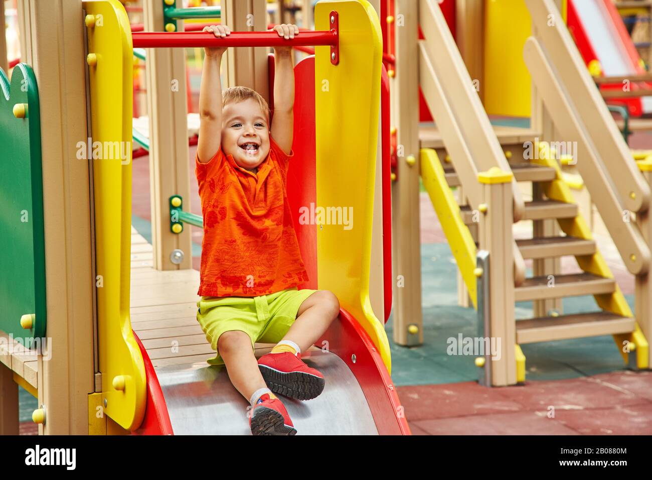 funny little boy on playground. playing child on slide Stock Photo - Alamy