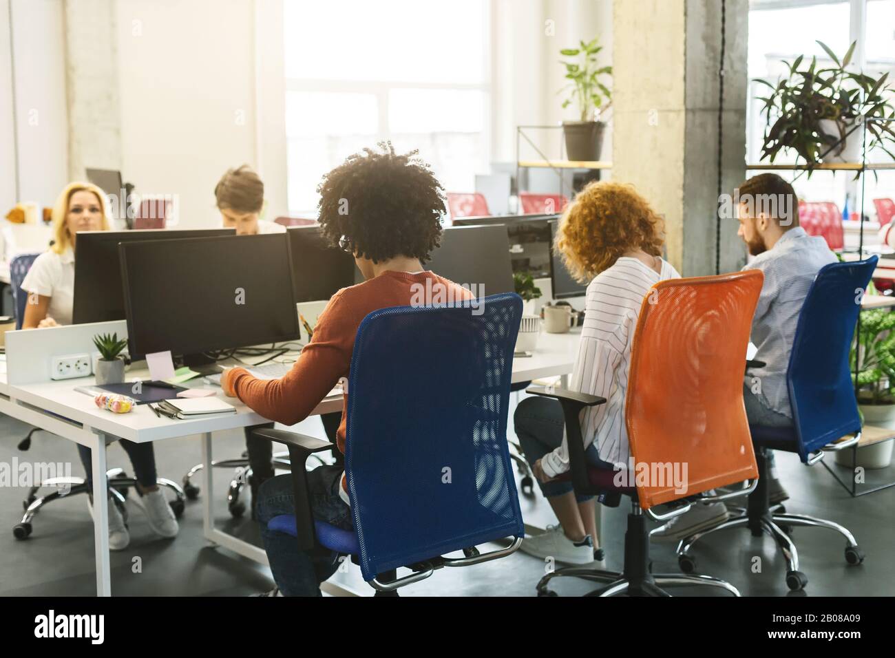 Back view of young business people working together Stock Photo - Alamy