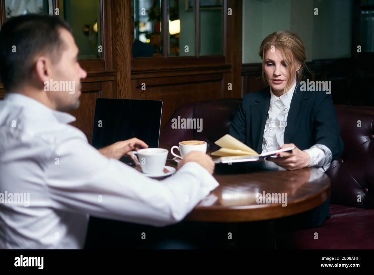 Business people talking over coffee in a cafe Stock Photo - Alamy