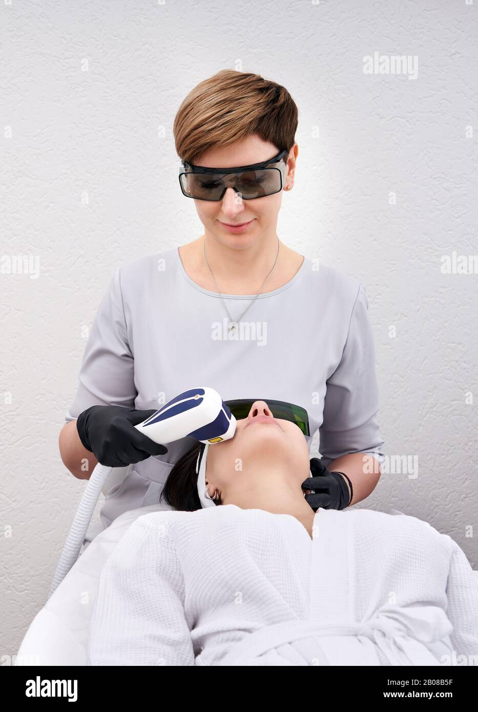 Young woman receiving laser treatment Stock Photo - Alamy