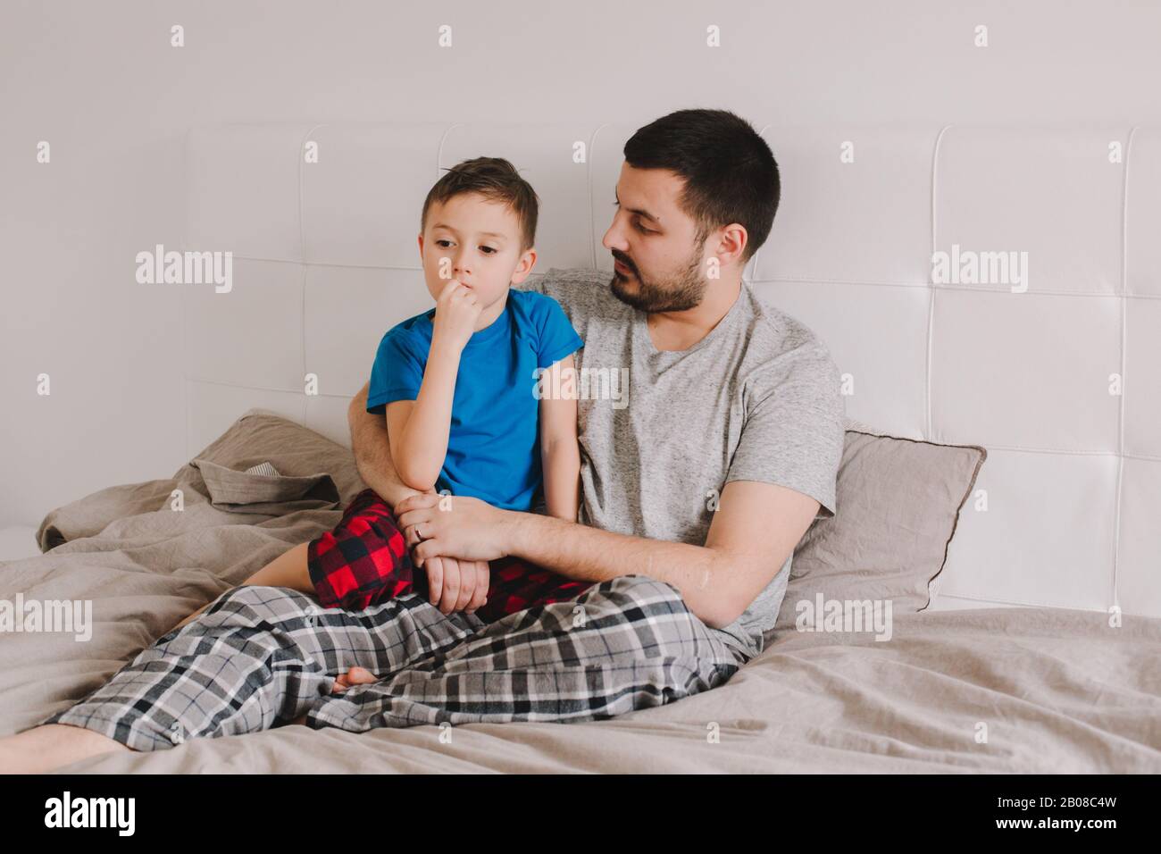 Young Caucasian father talking to boy son. Man parent hugging with ...