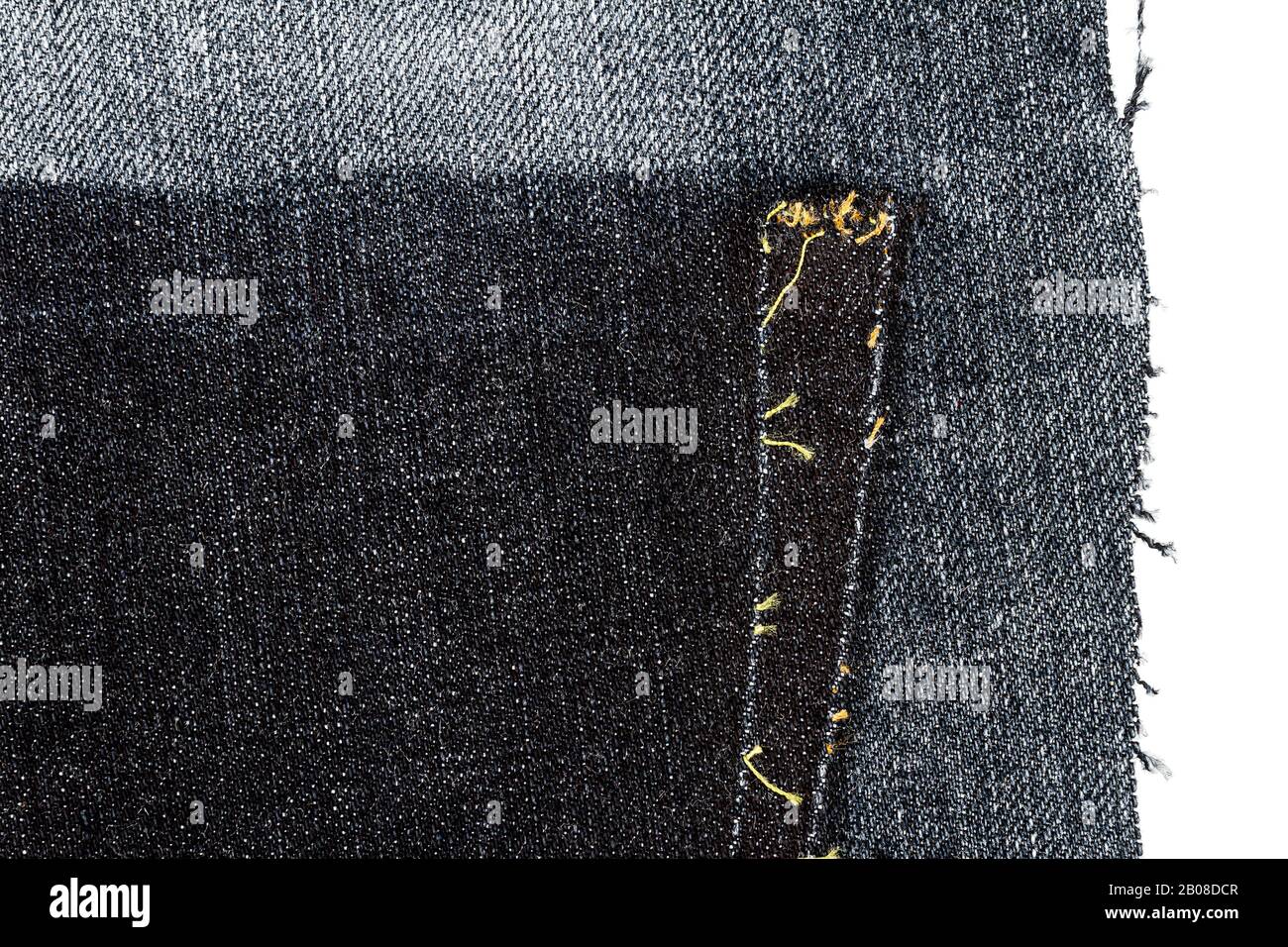Piece of black jeans fabric with a ripped of back pocket isolated on ...