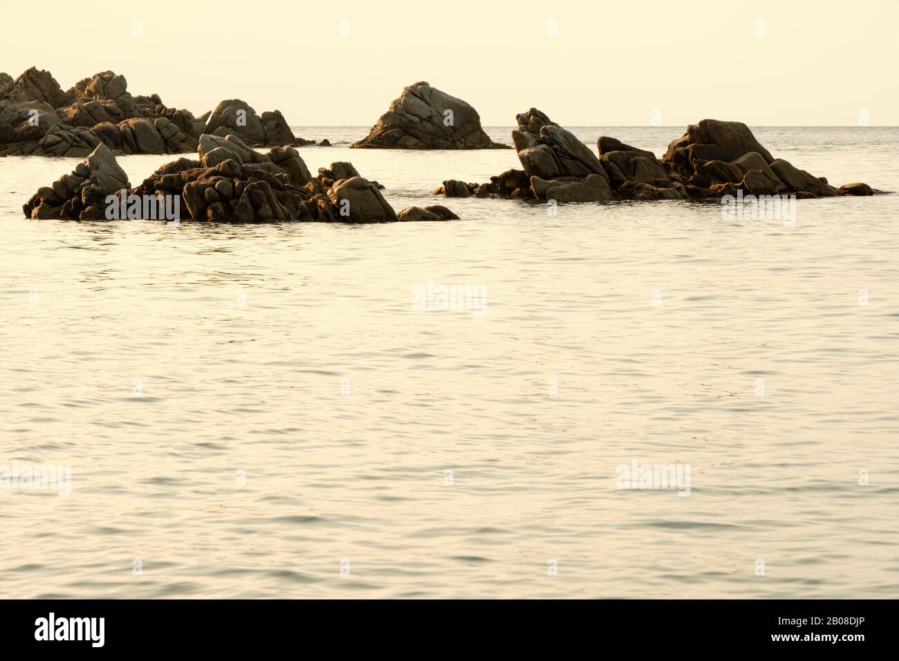 Rocks illuminated laterally by natural light in calm sea Stock Photo ...