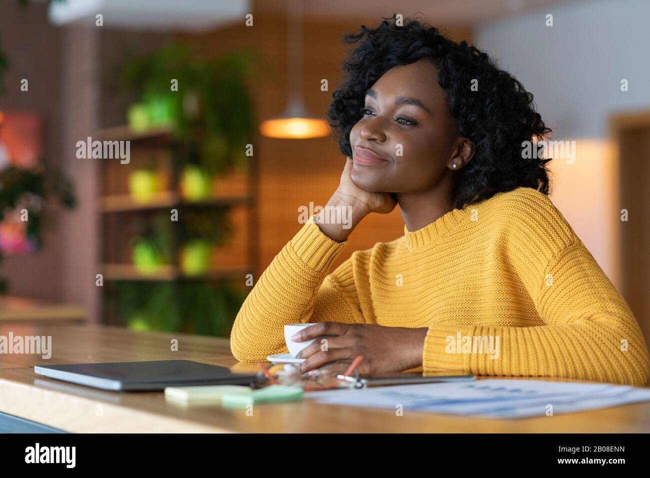 Relaxed afro girl enjoying cup of coffee during lunch break Stock Photo ...
