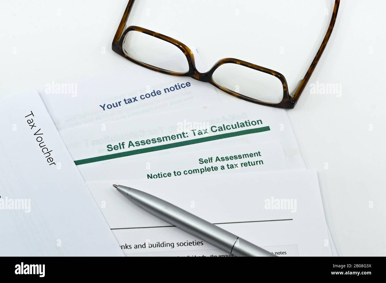 Close up view of a self assessment tax return form with a pen, a pair ...