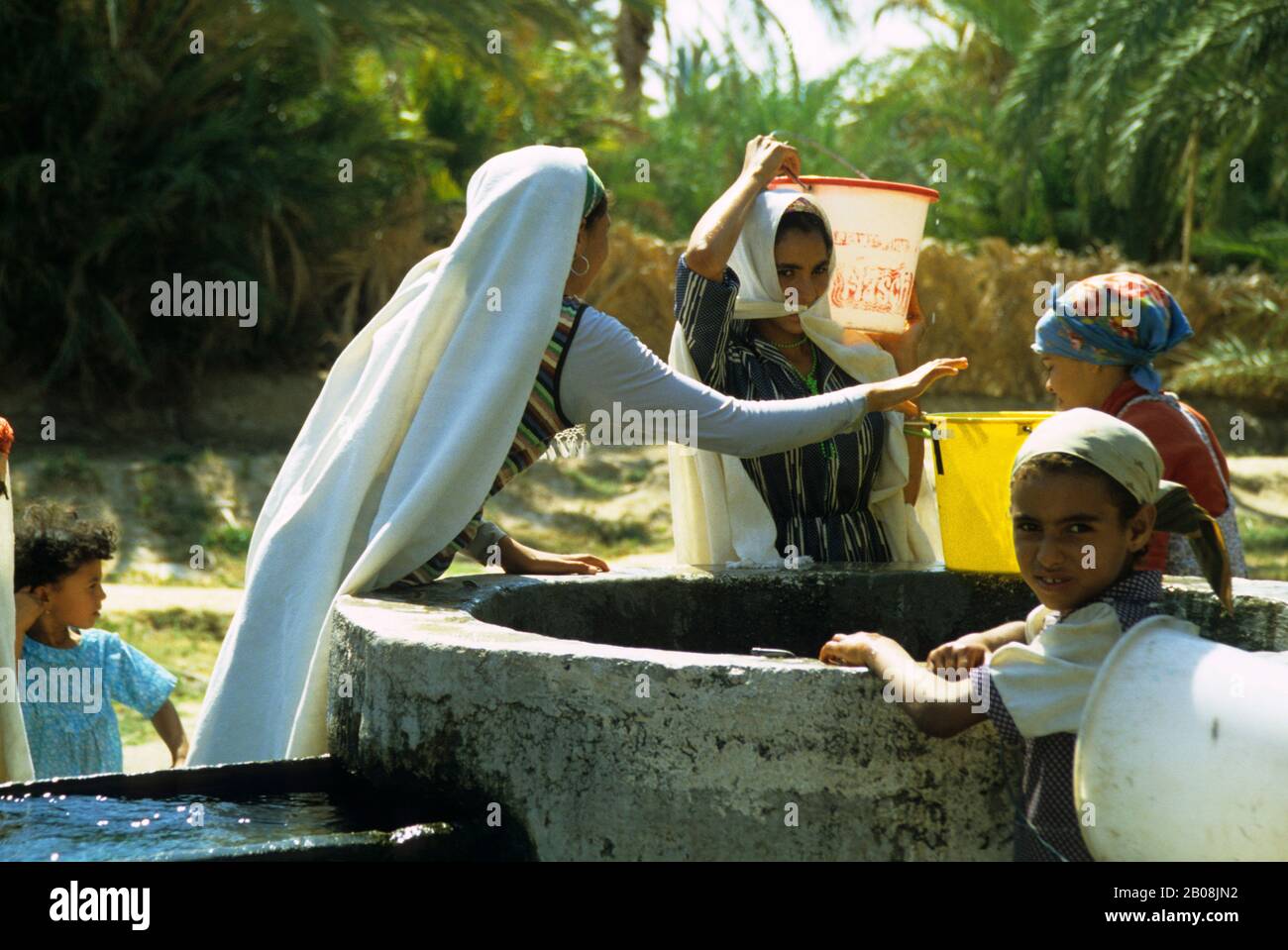 AFRICA, TUNISIA, SAHARA DESERT, OASIS, WOMEN DRAWING WATER FROM WELL ...