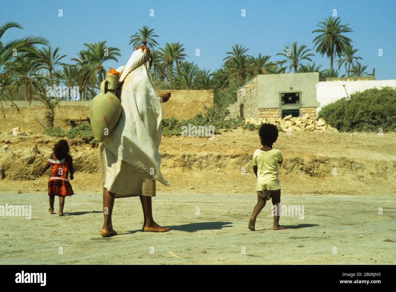 AFRICA, TUNISIA, SAHARA DESERT, OASIS, WOMAN CARRYING WATER FROM WELL ...