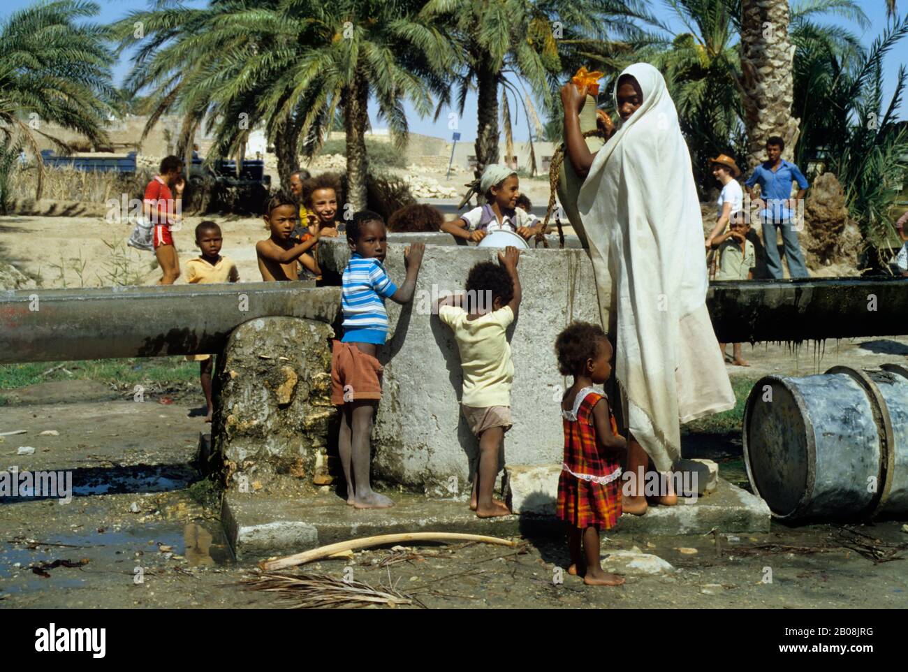 TUNISIA, SAHARA DESERT, OASIS, WOMAN DRAWING WATER FROM WELL Stock ...