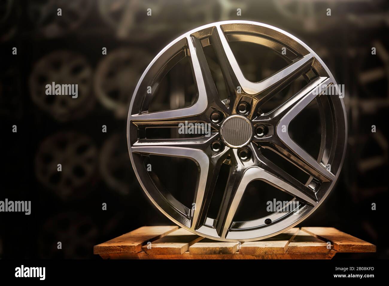 Modern automotive alloy wheel made of aluminum on a black background ...
