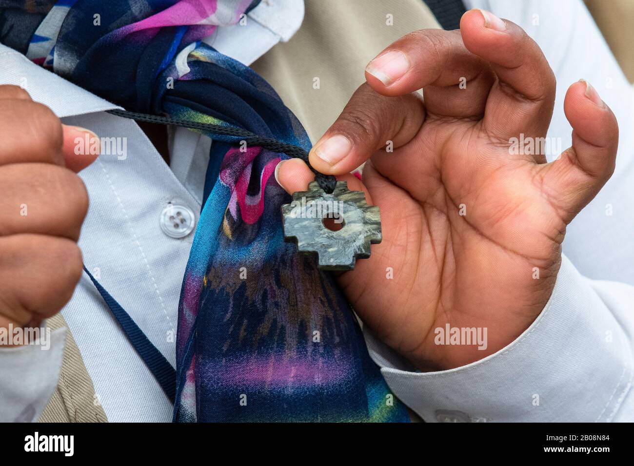 The Chakana or Inca cross being worn around the neck and being held up ...