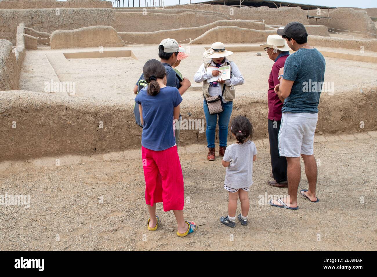 A family group of tourists having a guided tour of Chan Chan ...