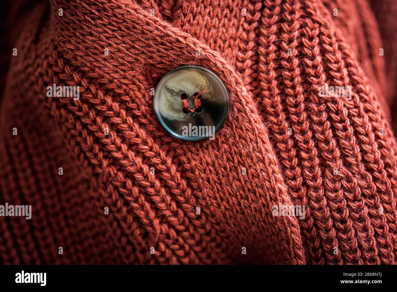 Upper button of a natural wool knitted cardigan Stock Photo - Alamy