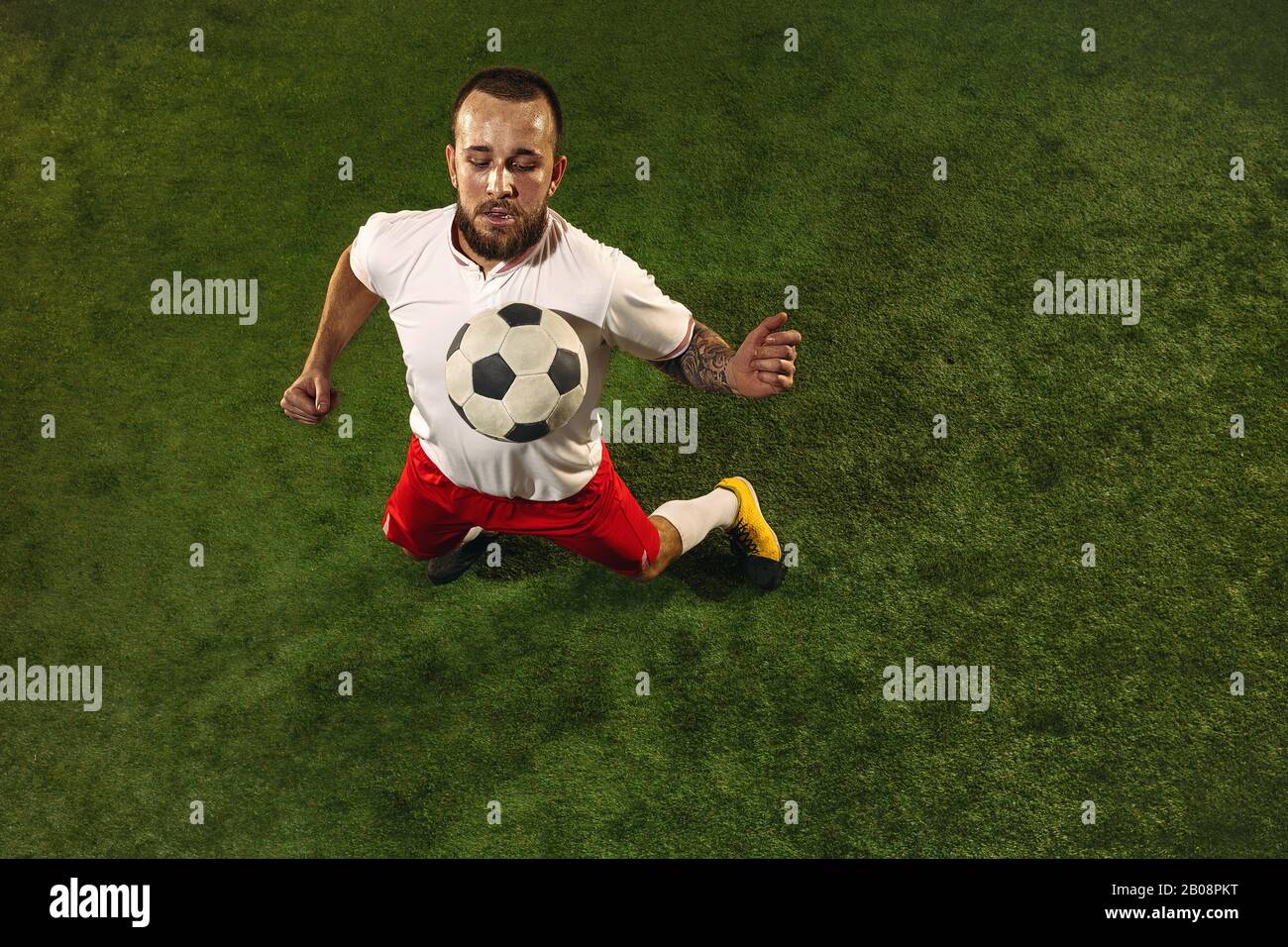 Top view of caucasian football or soccer player on green background of ...