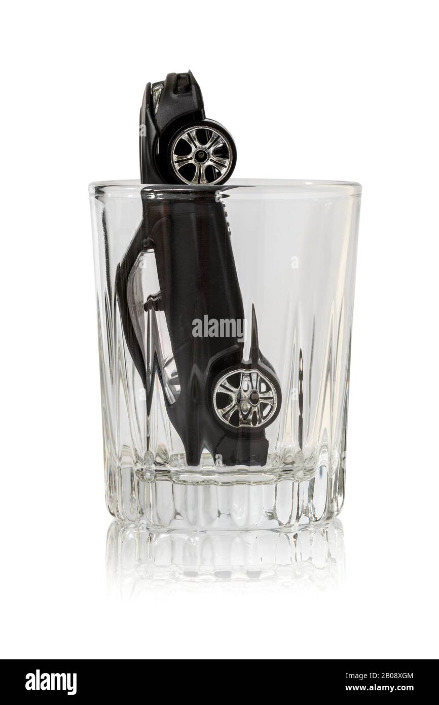 Toy car in a vodka glass isolated on white background. The concept of ...