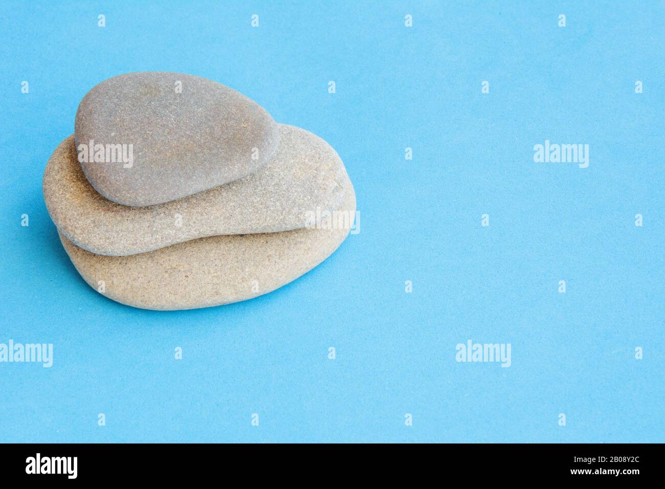 Stack of balanced stones of pebble zen on blue background. Balance ...