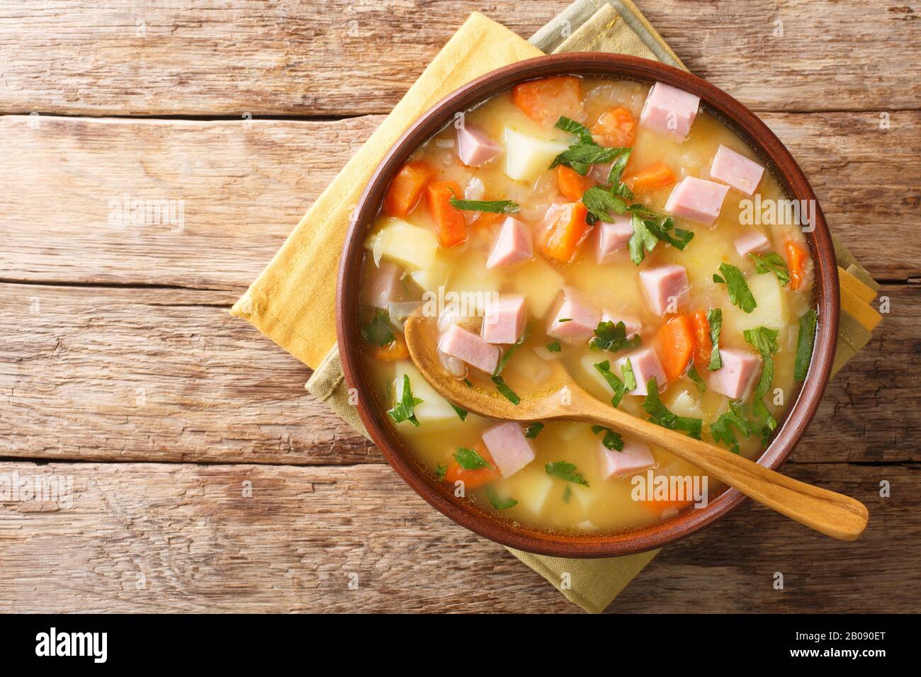 Serving of split pea soup with ham close-up in a bowl on the table ...