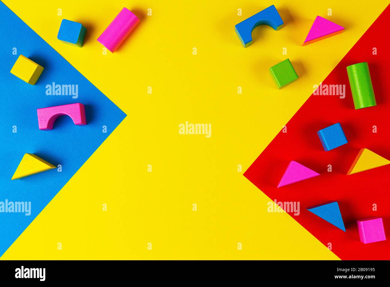 Wooden colorful blocks on geometric yellow blue red background. Top ...