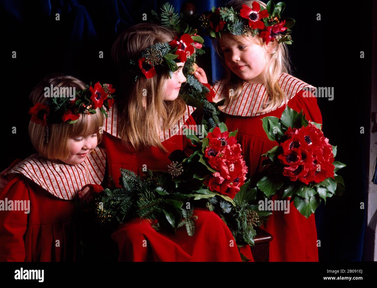 Three girls in red velvet dresses Stock Photo - Alamy