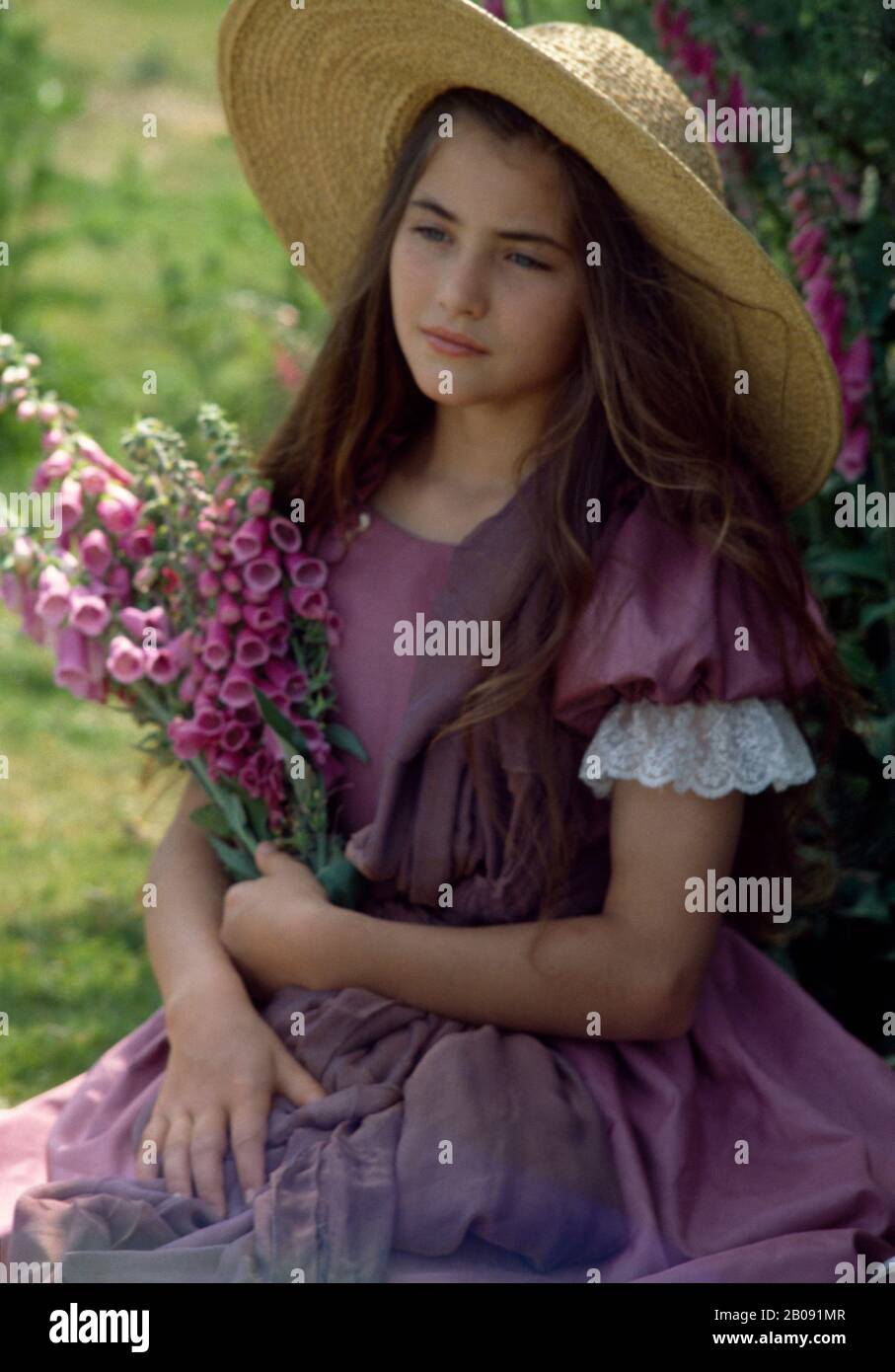 Closeup of teenage girl in mauve dress holding baunch foxgloves Stock ...