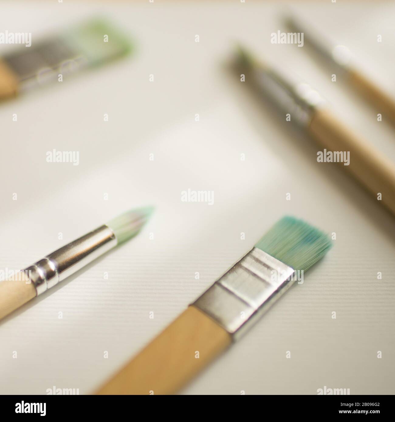 Used different brushes with wooden handles on white paper Stock Photo ...