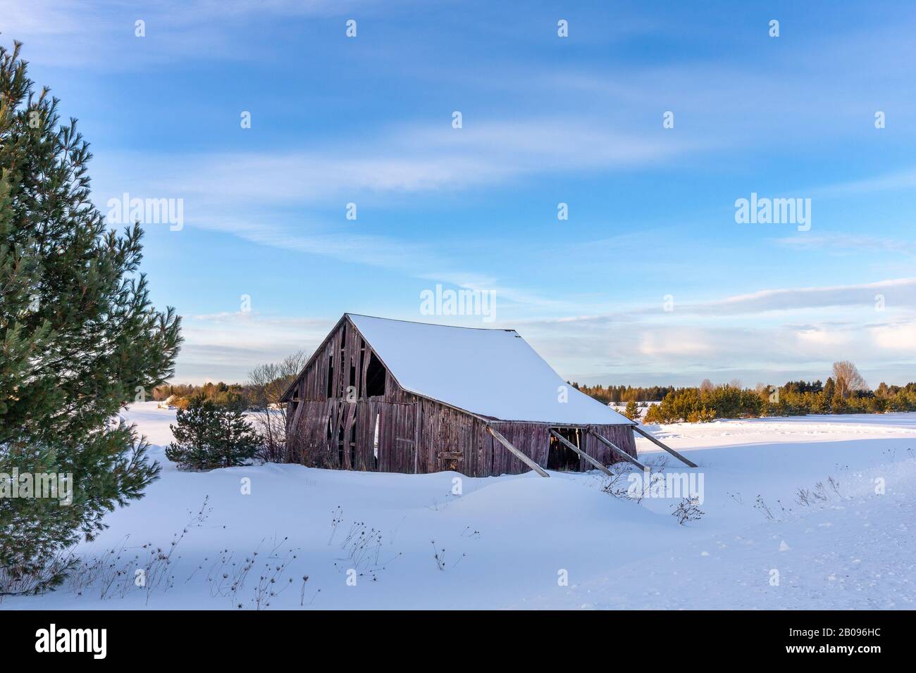 Weathered shed or barn in a snowy field in winter. Concepts could ...