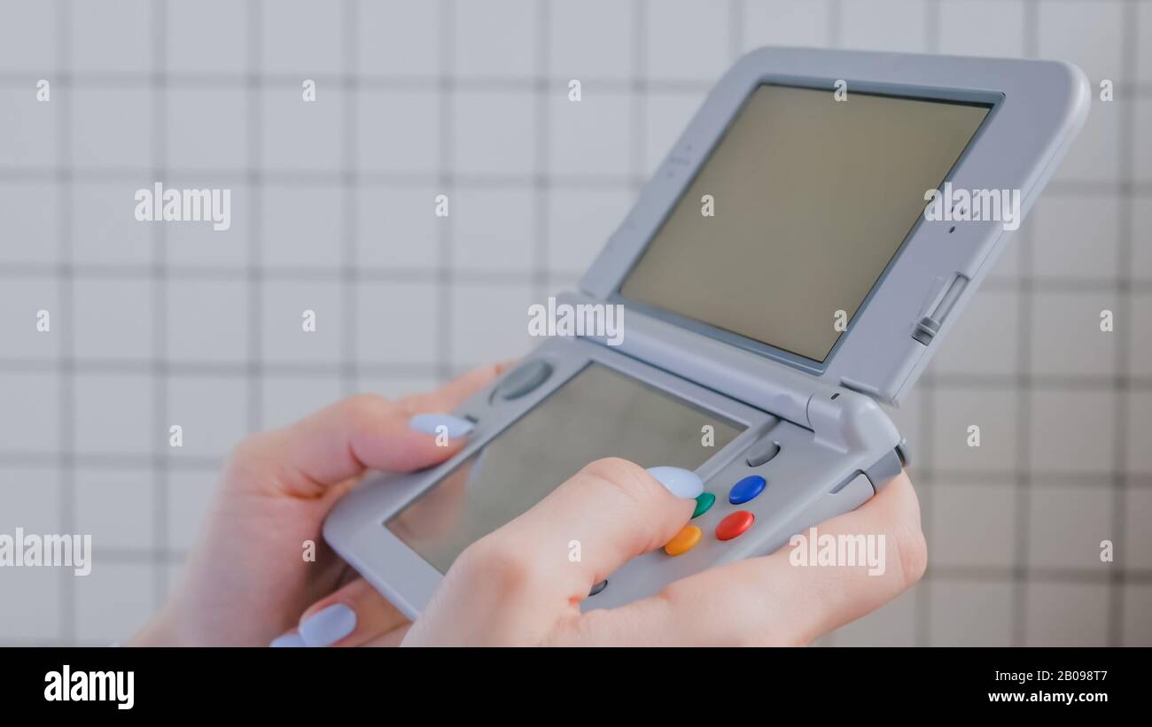 Woman playing grey portable game console - close up side view Stock ...