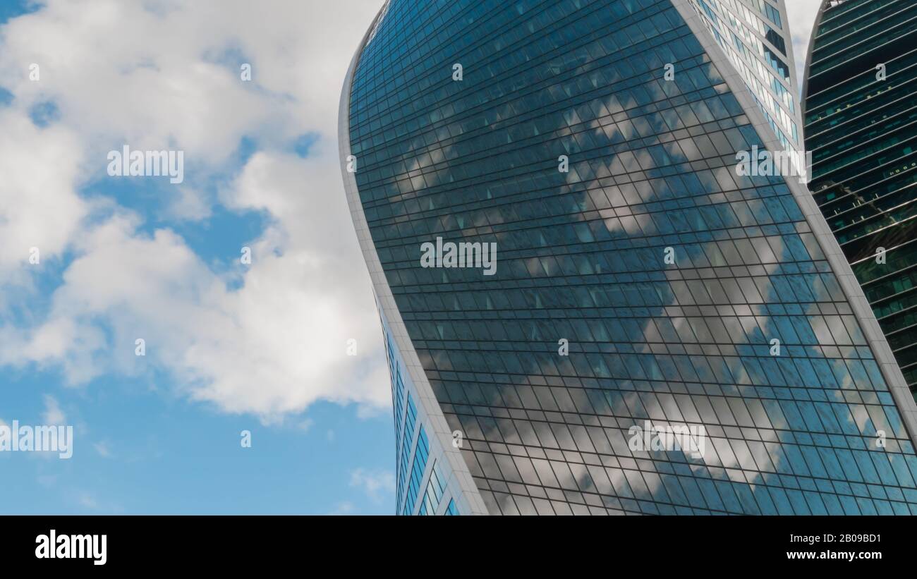 Reflection of white clouds in glass wall of modern skyscraper Stock ...