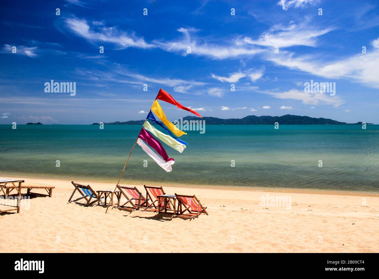 beach chairs with colorful flags at ocean front Stock Photo - Alamy