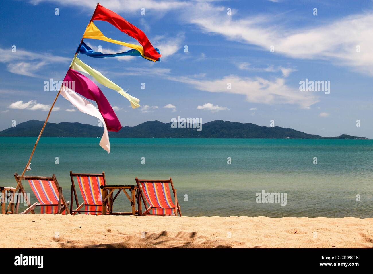beach chairs with colorful flags at ocean front Stock Photo - Alamy