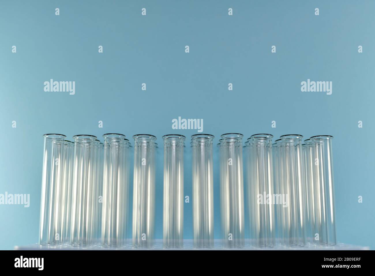 Group of test tubes of transparent glowing glare on a blue background ...