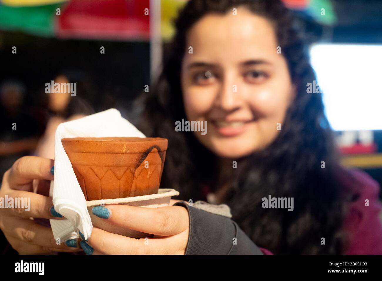 Young indian girl holding an earthenware clay pot of tandoori chai tea ...