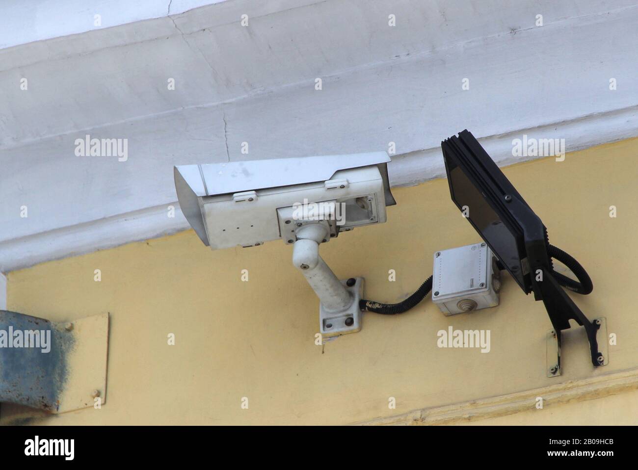 Surveillance camera mounted on tiled wall of house. Security concept ...