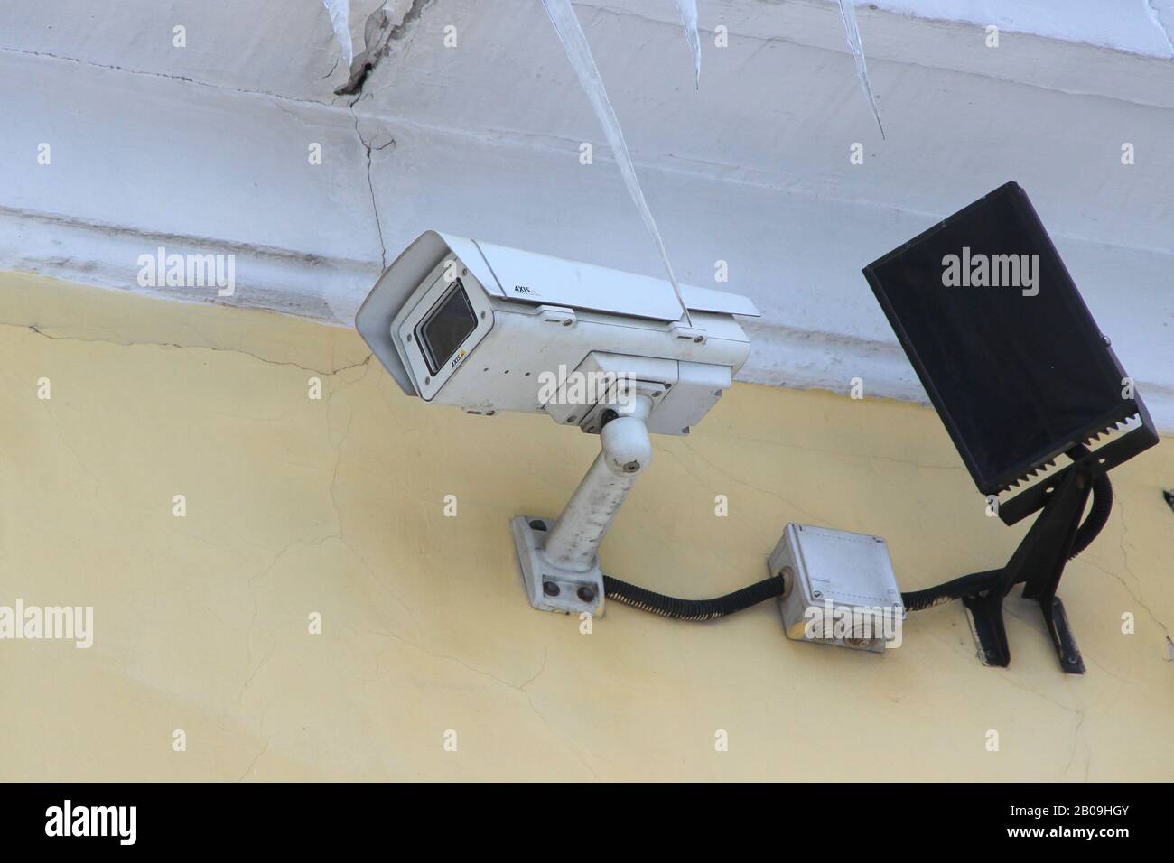 Surveillance camera mounted on tiled wall of house. Security concept ...