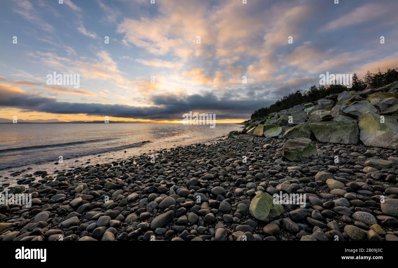 Beautiful dynamic sunrise over the coast with dramatic clouds over ...