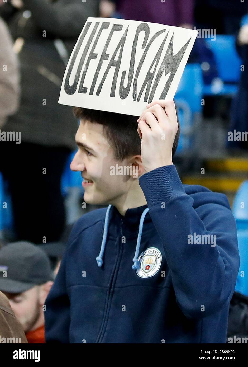 A Manchester City fan holds up a sign reading "UEFA SCAM" in the stands ...