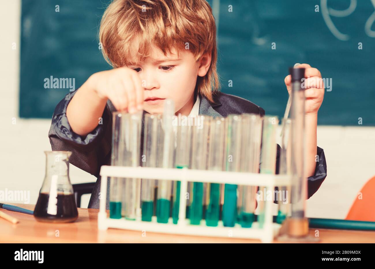 Science concept. Wunderkind experimenting with chemistry. Boy test ...