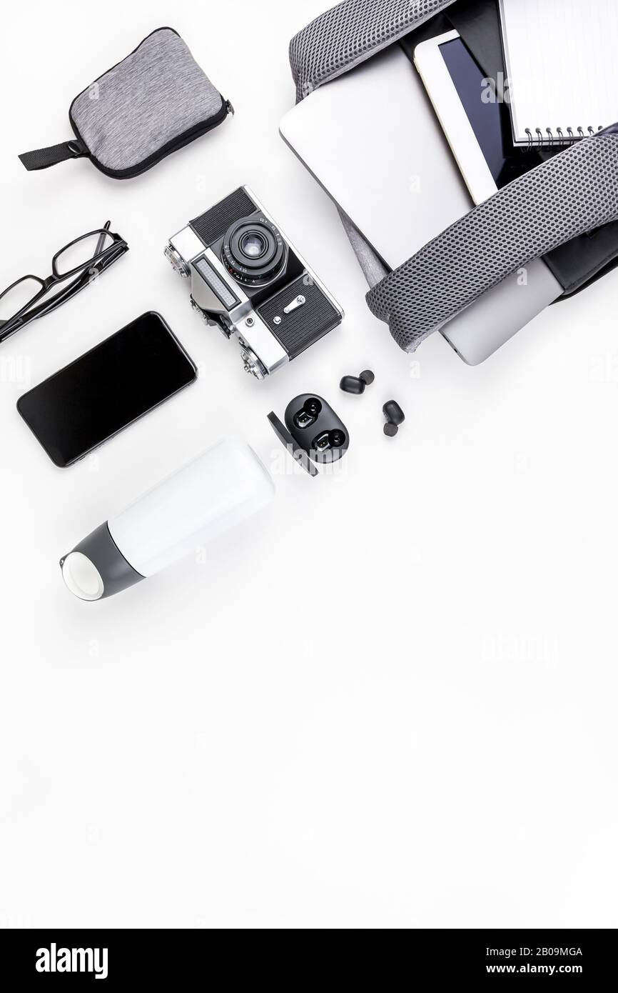 Creative top view flat lay of open backpack with laptop and tablet ...