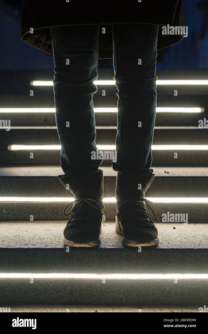 Female legs in suede winter boots, walking down the illuminated stone ...