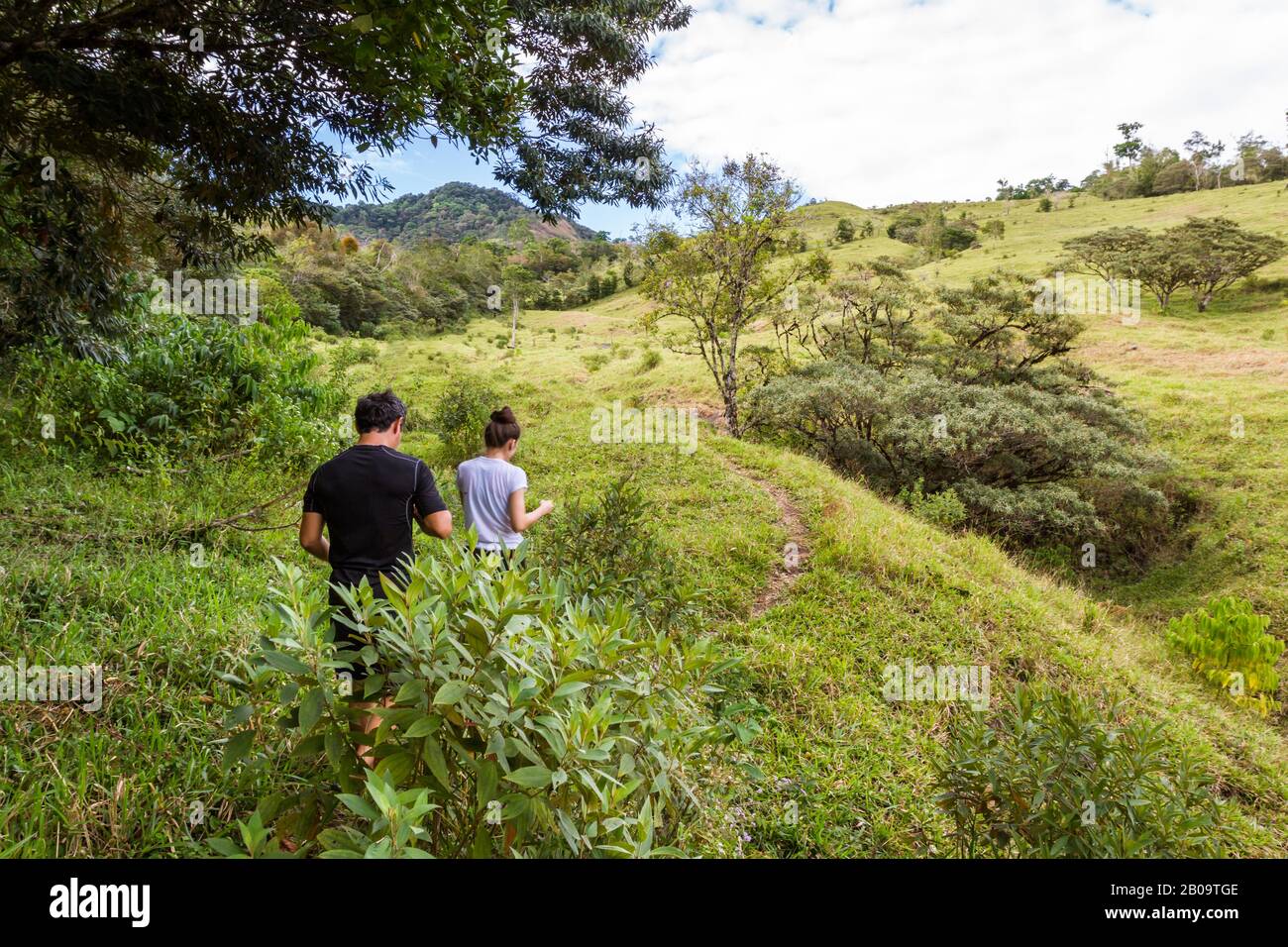 couple walking in rural Costa Rica with fresh green grass covering the ...