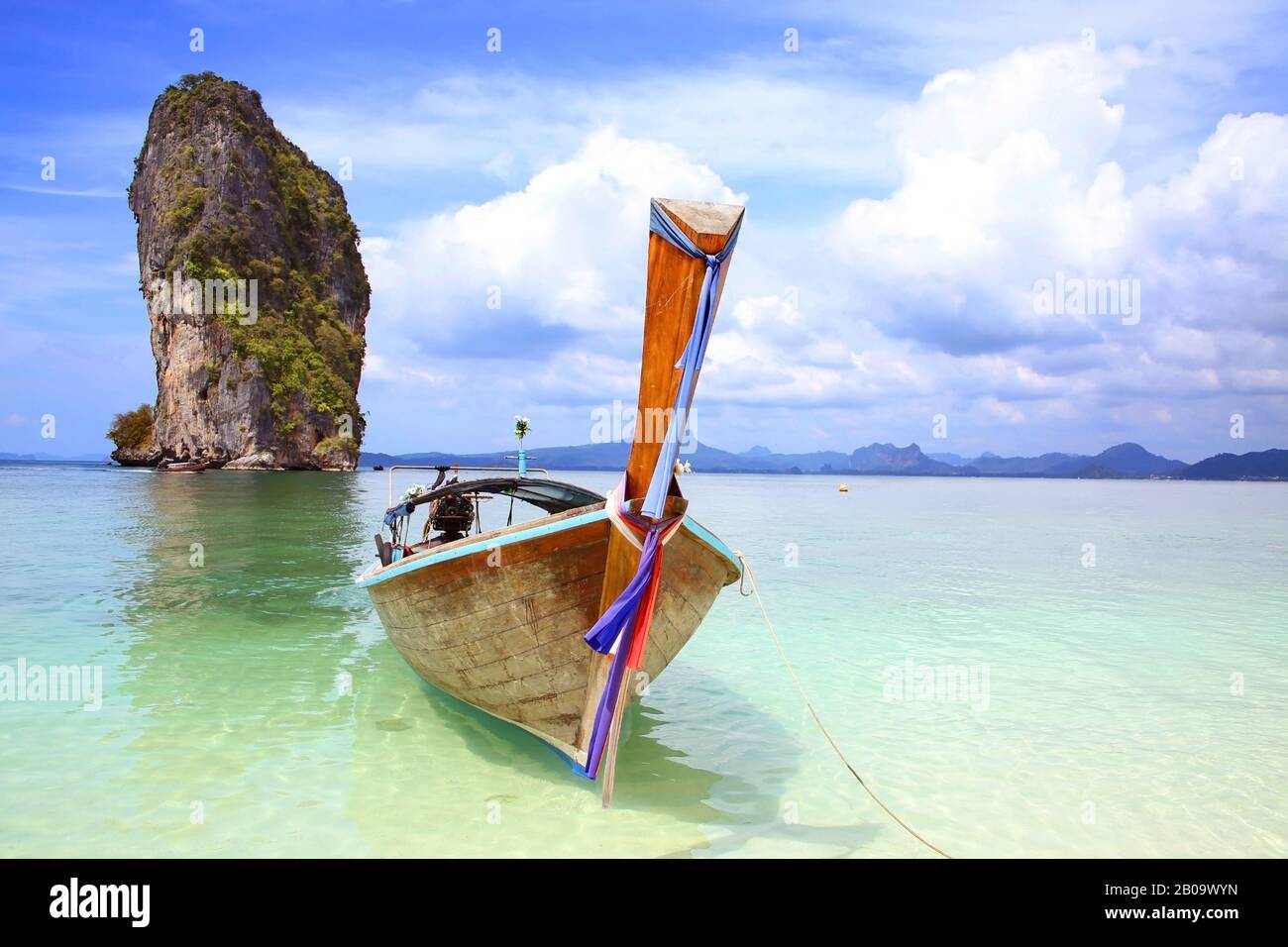 One Thai fishing boat tied up on the beach with a beautiful island in ...
