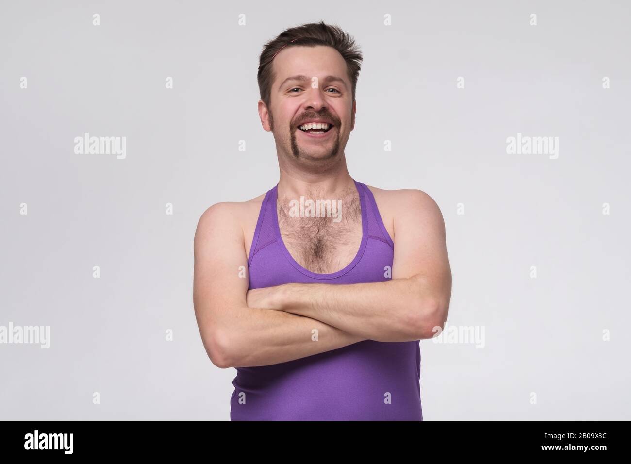 Attractive confident young man with mustache smiling on white wall ...