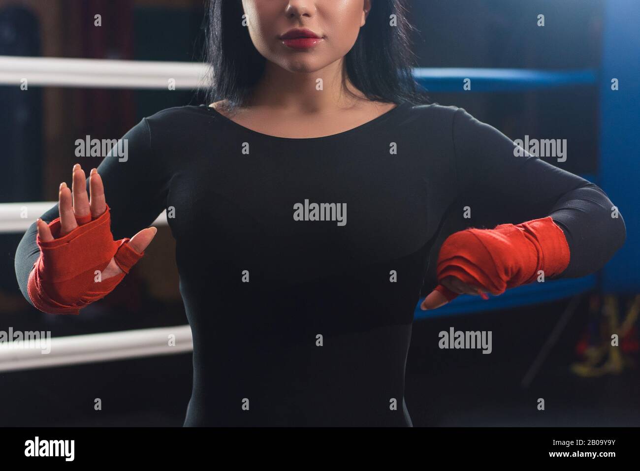 Boxer woman hands with red boxing wraps in the boxing ring. Closeup ...