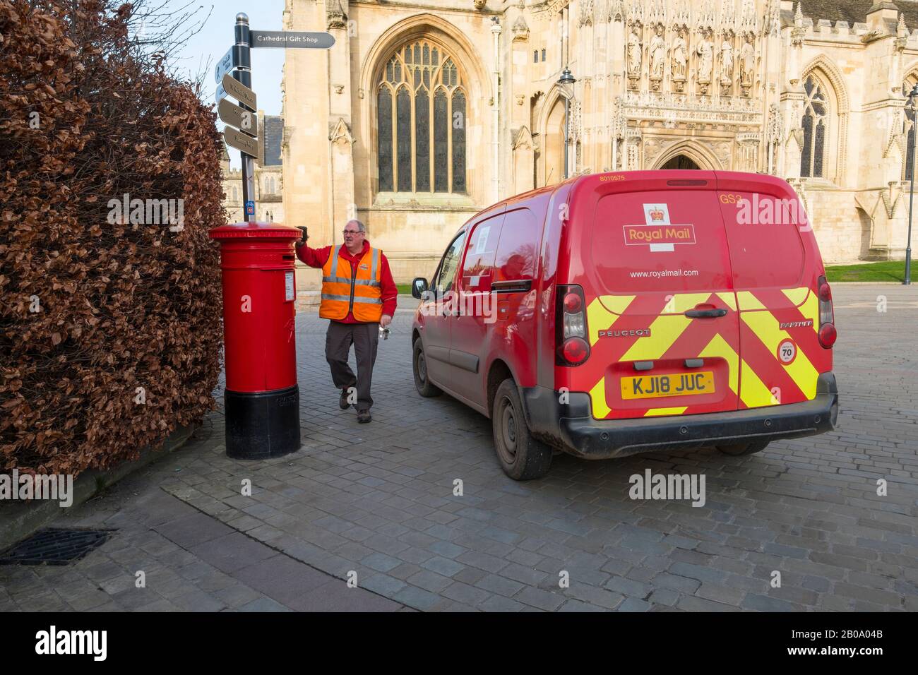 A Postman prepares to empty a post box outside Gloucester Cathedral ...