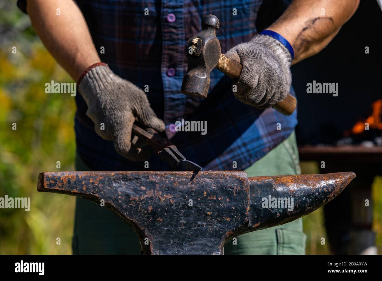 A close up selective focus shot of a traditional blacksmith, using an ...